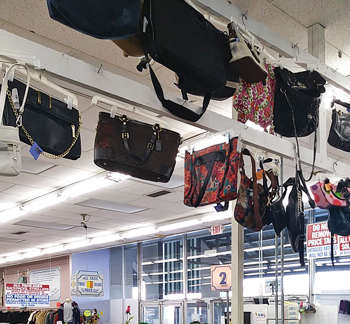 Bags upon bags upon bags! Like fashionable stalactites hanging from the ceiling, these purses wait patiently for someone to recognize their second-chance potential.