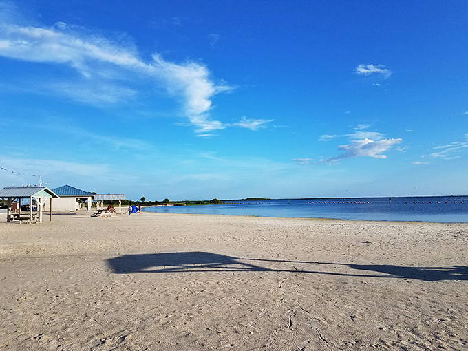 Impossibly blue skies stretch endlessly over Fort Island's shoreline, where simplicity and natural beauty trump commercial beach chaos.