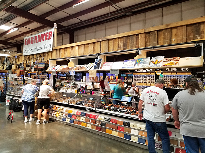 The engraver's booth&mdash;where personalization meets craftsmanship. Those sunglasses aren't just accessories; they're future family heirlooms waiting for your name.