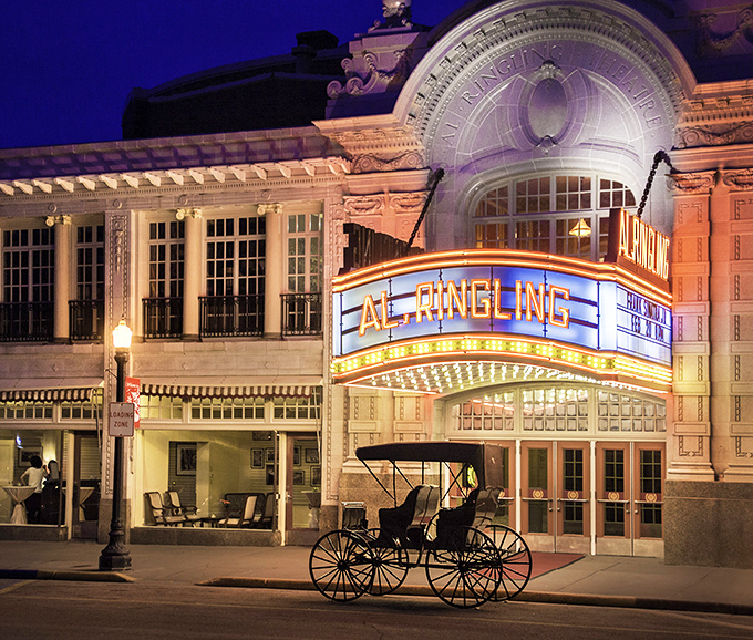The Al. Ringling Theatre glows at night like a jewel box of entertainment, complete with horse-drawn carriage&mdash;because Ubers were scarce in 1915.