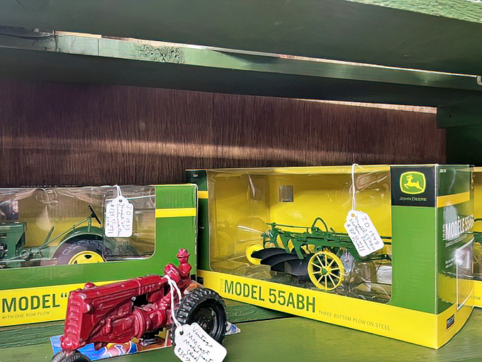 These miniature John Deere tractors aren't just toys&mdash;they're childhood memories for farmers who once dreamed of driving the real thing. Green and yellow nostalgia, boxed and waiting.