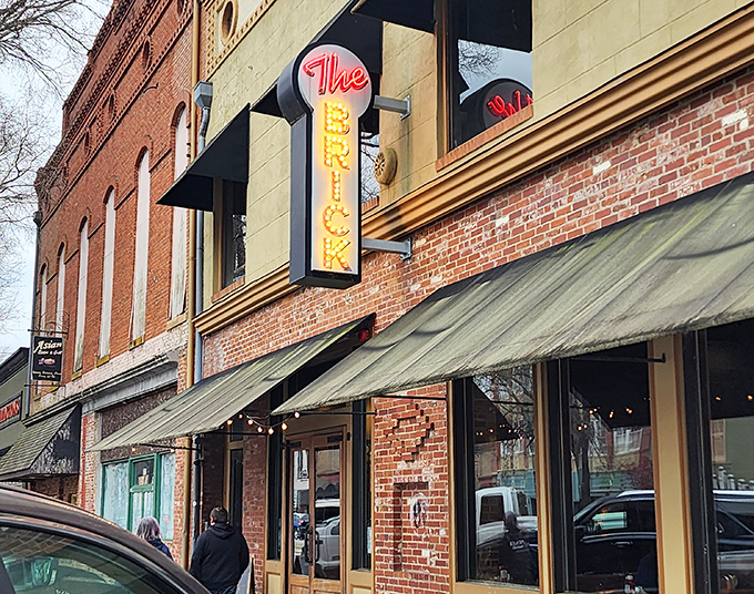 The Brick's iconic neon sign beckons hungry travelers like a lighthouse for the famished. Inside awaits comfort food that makes calorie-counting seem like a crime against humanity.