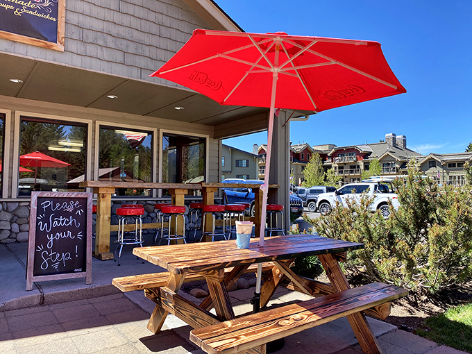 Nothing says "vacation mode activated" like a red umbrella and a wooden picnic table. This spot practically begs you to linger.
