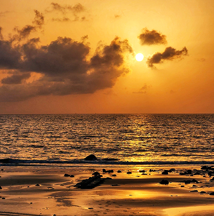 Golden hour transforms Driftwood Beach into a painter's dream, with the setting sun casting its warm glow across the peaceful waters.