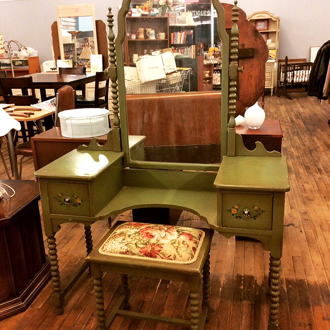 This mint-green vintage vanity isn't just furniture; it's a time portal to morning routines of decades past, complete with floral-cushioned stool.