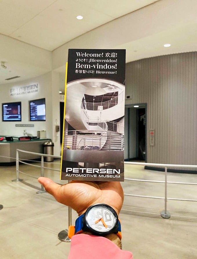 The museum's multilingual welcome brochure&mdash;your passport to automotive nirvana. The spiral staircase beckons like a mechanical DNA strand.