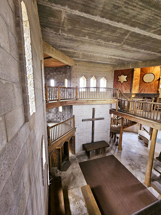 The interior reveals the castle's true purpose&mdash;a spiritual sanctuary where rustic wooden balconies frame a simple cross in contemplative silence.