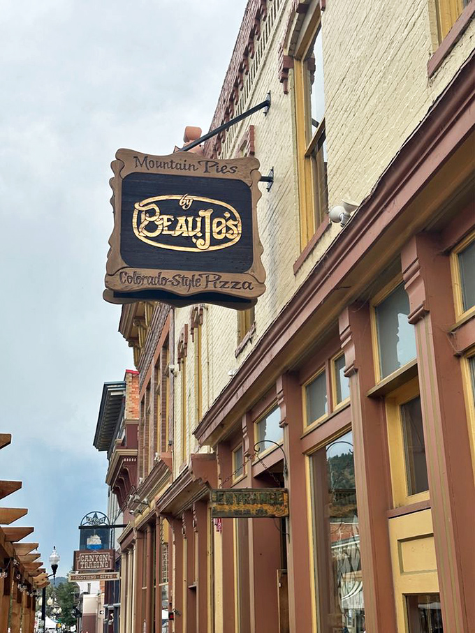 Beau Jo's wooden sign swinging in mountain air&mdash;like a dinner bell for hikers with empty stomachs.