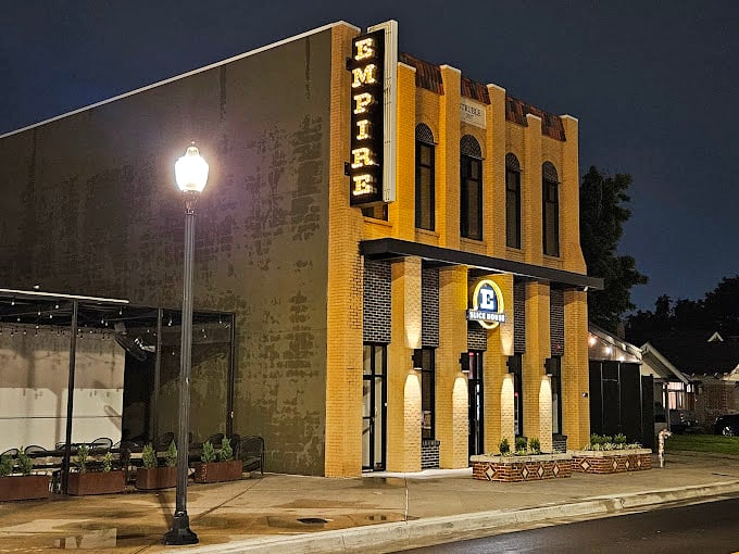 Empire Slice House lights up after dark like a pizza-powered lighthouse. That golden glow promises New York-style slices with Oklahoma charm.