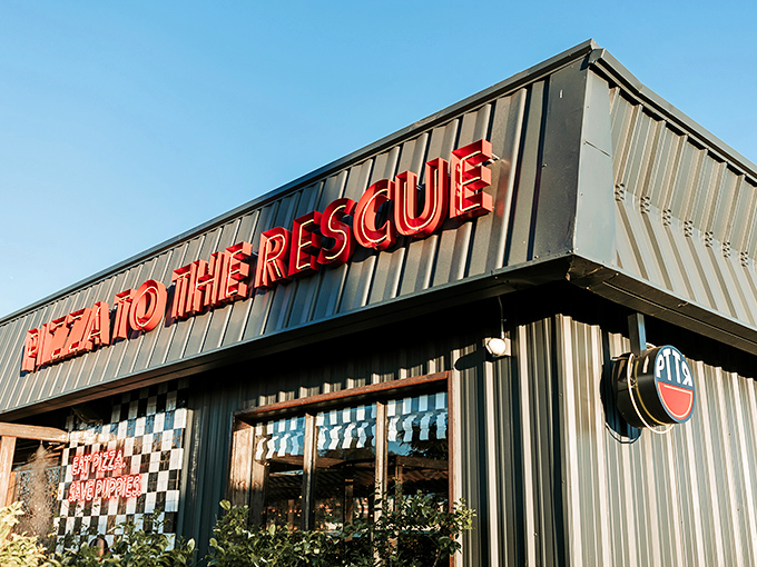 "Pizza To The Rescue" isn't just a clever name&mdash;it's a promise delivered in neon. The black and white checkerboard facade adds a touch of retro charm.