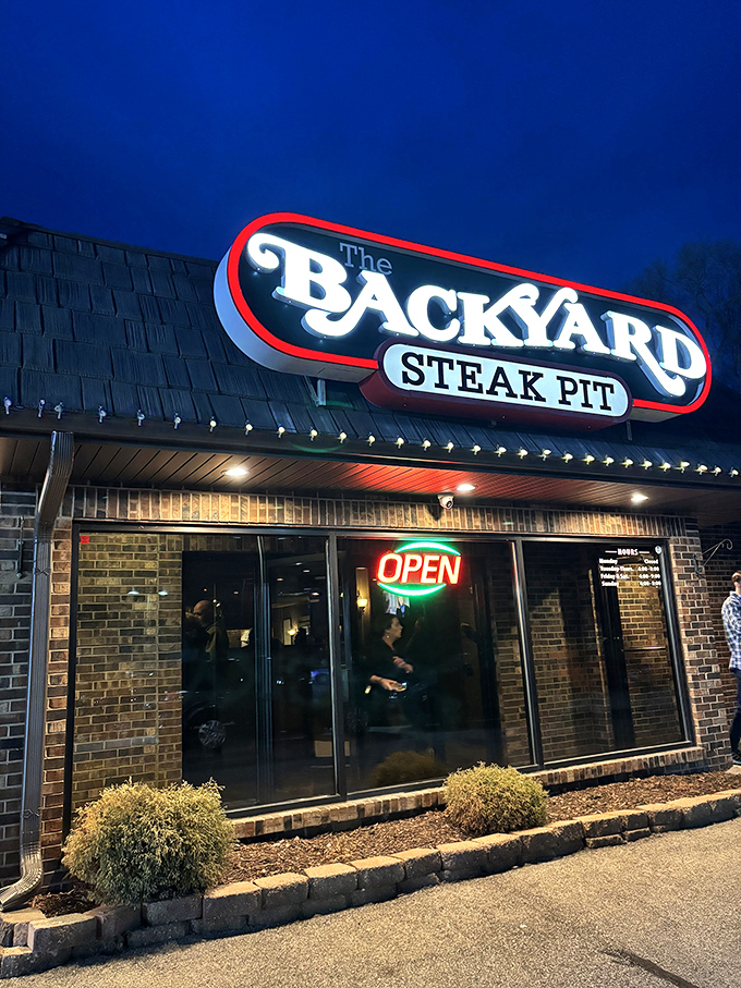The Backyard Steak Pit's neon glow is like a lighthouse for the carnivorous soul on a hungry night.
