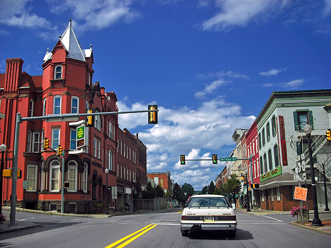 The striking red Victorian architecture of downtown Pottsville stands out against blue skies. These historic buildings house affordable apartments above street-level businesses.