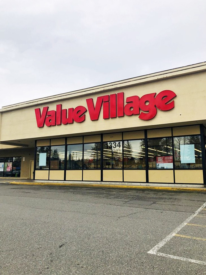 Value Village's bold red sign beckons like a lighthouse to shipwrecked shoppers seeking affordable treasures.