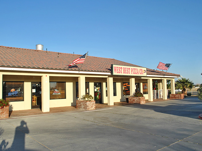 West Best Pizza's unassuming exterior hides pizza treasures within. Those American flags aren't just patriotic – they're waving you inside.