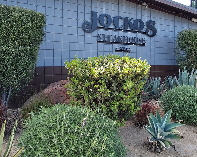 This modest steakhouse entrance belies the oak-fired magic happening inside, where smoke transforms beef into dreams.