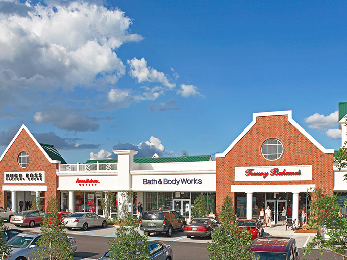 Williamsburg Premium Outlets creates a shopping village where Bath & Body Works neighbors Tommy Hilfiger. Cars patiently wait while their owners discover treasures inside.