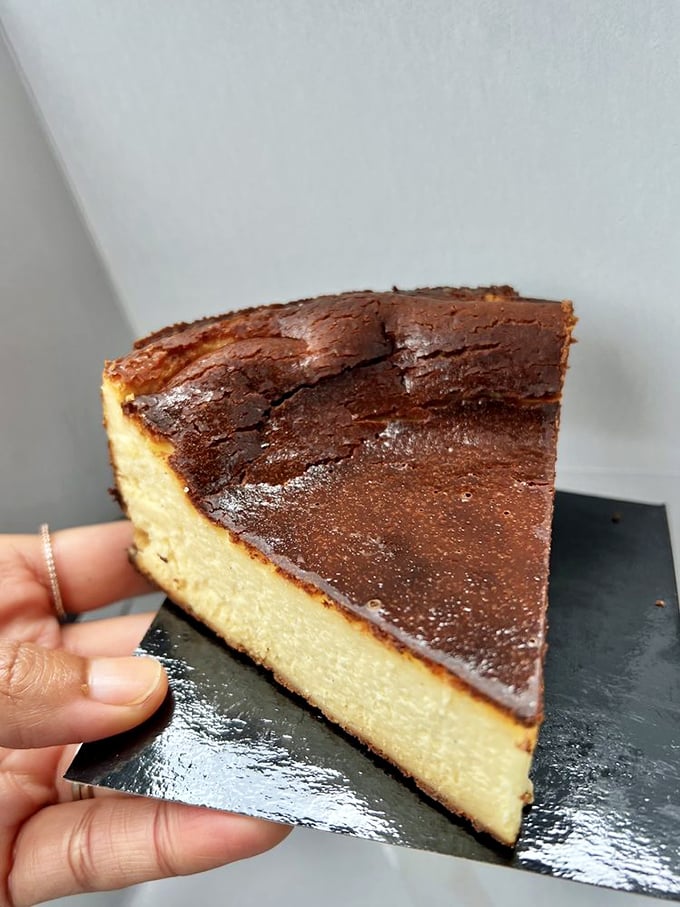 Behold the Basque cheesecake in all its burnished glory—a creamy interior beneath that caramelized top will make you question all other desserts.