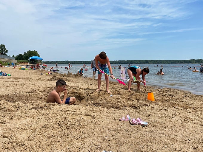 Sandcastle architects and water splashers hard at work. Summer memories being built one bucket of sand at a time.