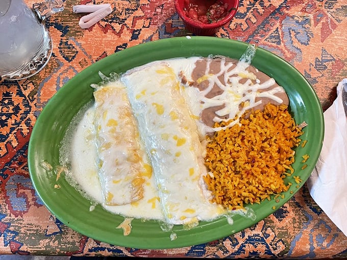 Cheese-blanketed enchiladas nestled against golden Spanish rice&mdash;a plate that whispers, "Diet plans can resume tomorrow."