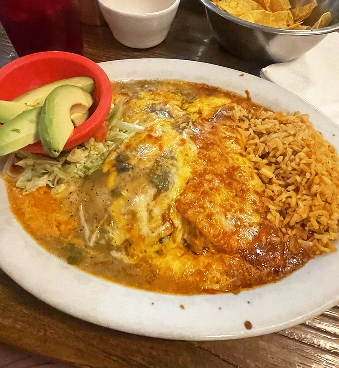This isn't just an enchilada—it's a masterpiece of melted cheese, savory sauce, and perfectly seasoned beef with a side of Mexican rice that demands attention.