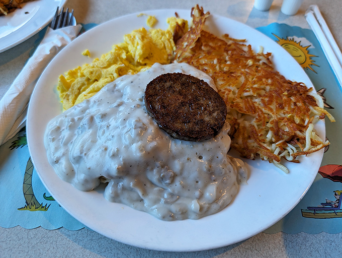Biscuits swimming in creamy gravy alongside golden hash browns and fluffy eggs – the breakfast trinity that makes mornings worth waking up for.