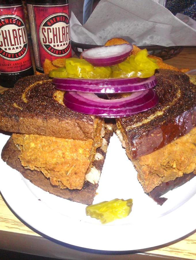 Behold the legendary brain sandwich in its natural habitat, complete with purple onion rings and pickle sentries. Culinary courage never looked so good.