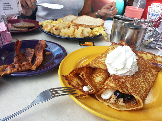 Behold the famous crepe-style hotcakes in their natural habitat! Crispy edges, pillowy centers, and that dollop of whipped cream melting just so.