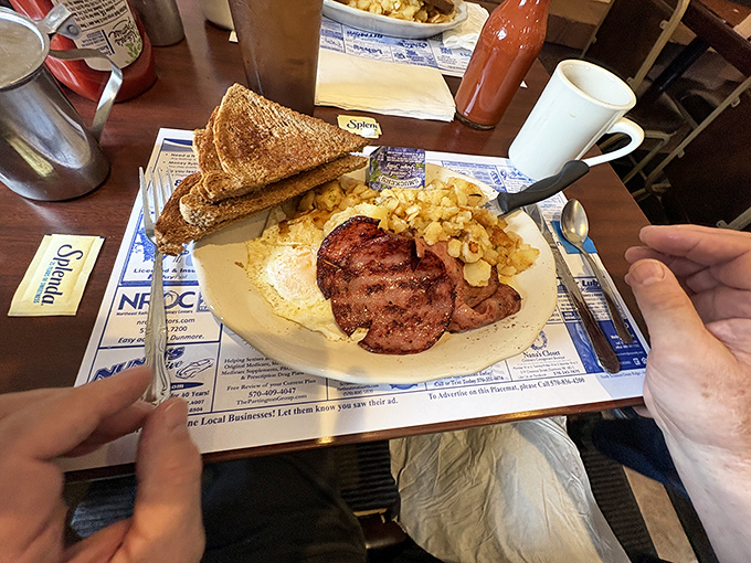 Breakfast perfection on a plate: golden toast, crispy home fries, and ham steak so substantial it could moonlight as a doorstop.