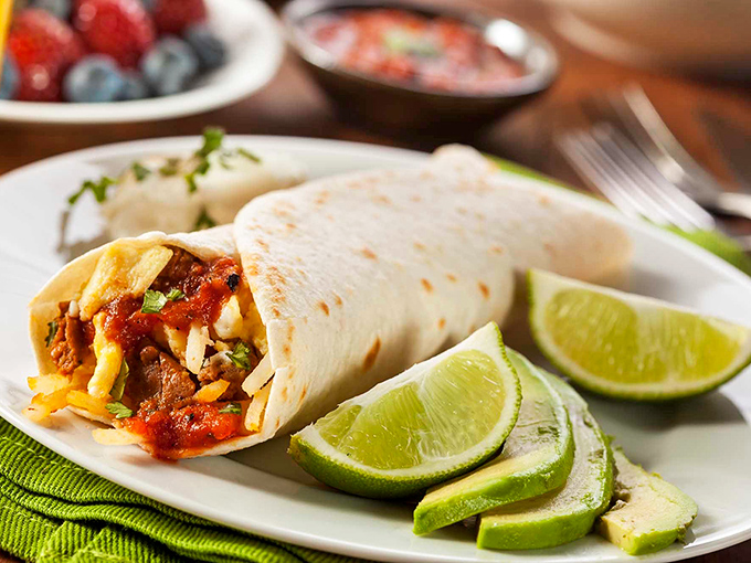 This isn't just a burrito&mdash;it's edible architecture. Perfectly wrapped with fresh lime wedges standing by, ready to add that crucial citrus zing to every magnificent bite.