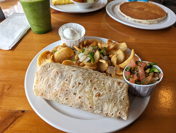 This breakfast burrito isn't just a meal, it's a commitment. Stuffed with morning goodness and served with home fries that could make a potato proud.