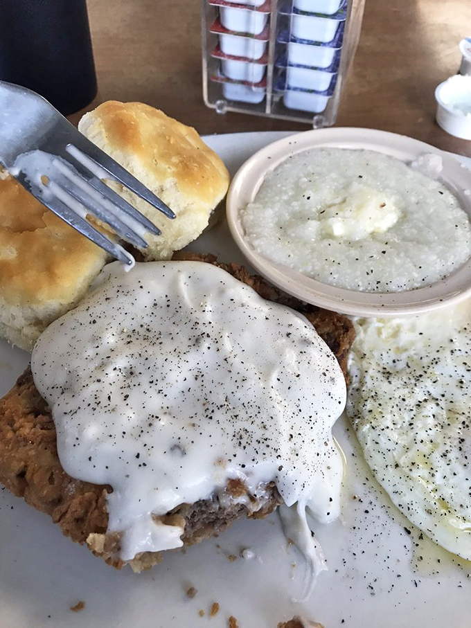 Country fried steak smothered in pepper-flecked gravy alongside fluffy biscuits and creamy grits&mdash;this is what breakfast dreams are made of.