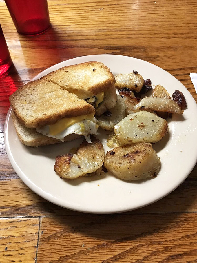 Breakfast sandwich perfection &ndash; golden toast hugging a sunny egg, with those home fries looking like they've been kissed by butter and seasoning.