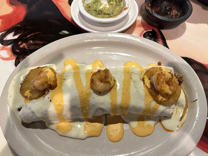 Behold the shrimp-topped masterpiece that dreams are made of. This burrito wears its queso sauce like a royal robe, crowned with perfectly grilled seafood.
