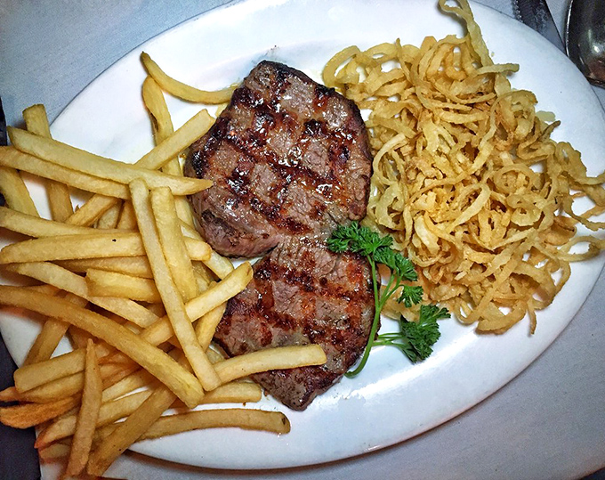 Steak perfection doesn't always wear fancy clothes. This butterflied filet with crispy fries and onion straws proves that sometimes the best things come on white plates.