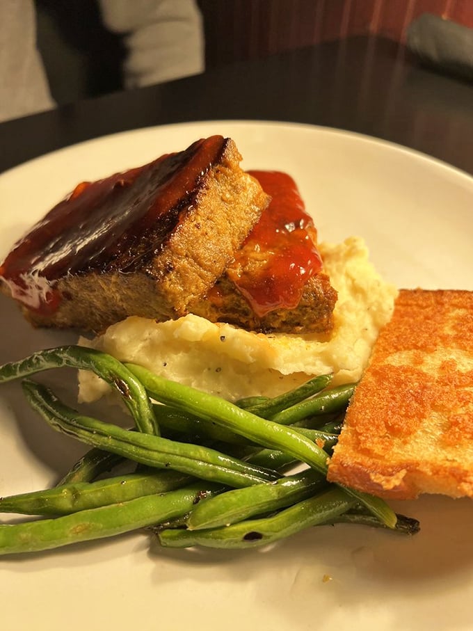 Behold the Cajun Meatloaf: perfectly glazed, expertly seasoned, and served with sides that complete this culinary masterpiece beautifully. 