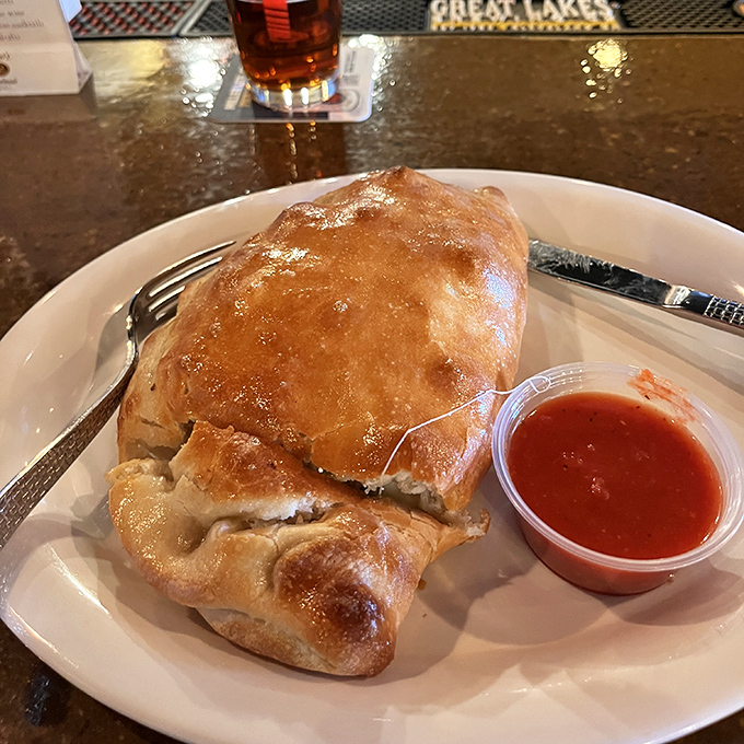 The calzone that launched a thousand road trips. Golden-brown, stuffed with molten cheese, and served with that signature marinara&mdash;this is handheld heaven.