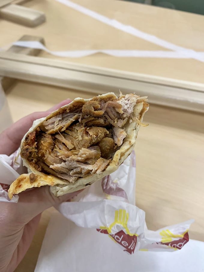 The carnitas burrito reveals its treasure trove of slow-cooked pork, each tender morsel telling a story of patience and tradition.