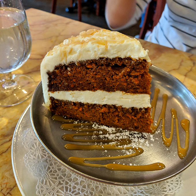 This towering carrot cake slice could end diplomatic disputes &ndash; layers of moist perfection crowned with cream cheese clouds.