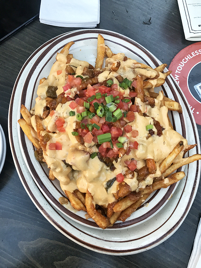 Fries achieving their highest calling&mdash;smothered in cheese, bacon, and green onions. Diet plans come here to die happy deaths.