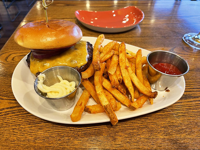Behold the classic cheeseburger in its natural habitat&mdash;a perfect specimen with golden fries standing guard. Simplicity executed flawlessly is culinary genius.