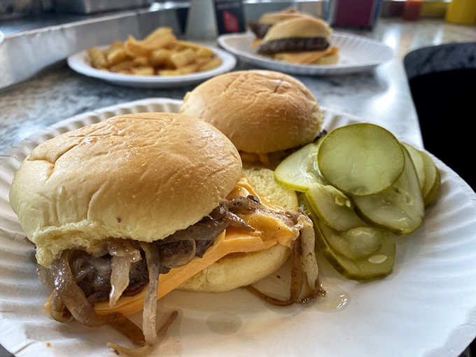 Slider perfection: caramelized onions melting into American cheese, nestled on a juicy patty. The pickle slices aren't garnish—they're essential supporting actors.