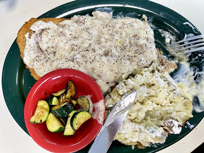 Behold the star of our show: chicken fried steak swimming in peppery gravy with a side of perfectly saut&eacute;ed zucchini. Poetry on a plate.