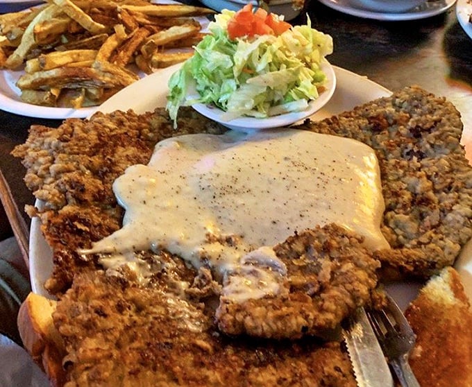 Behold the star of the show! This chicken fried steak extends beyond its plate borders like Texas itself &ndash; ambitious, unapologetic, and absolutely magnificent.