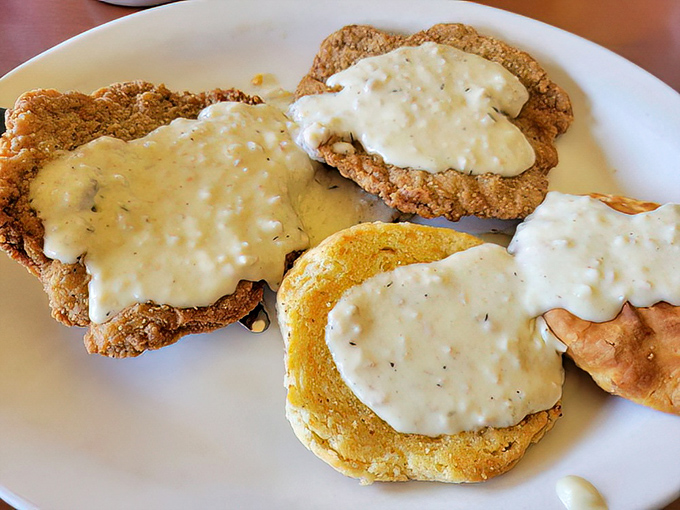 Behold the star attraction: chicken fried steak smothered in peppery country gravy that cascades over crispy edges like a savory waterfall of happiness.