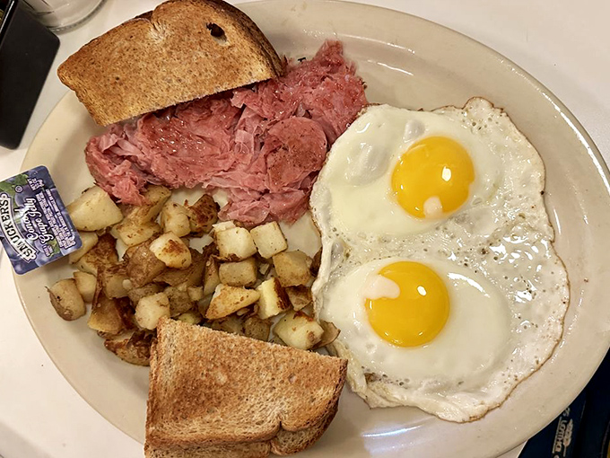 Breakfast perfection on a plate &ndash; those sunny-side-up eggs seem to be smiling at the mountain of thinly-shaved chipped ham and golden home fries.