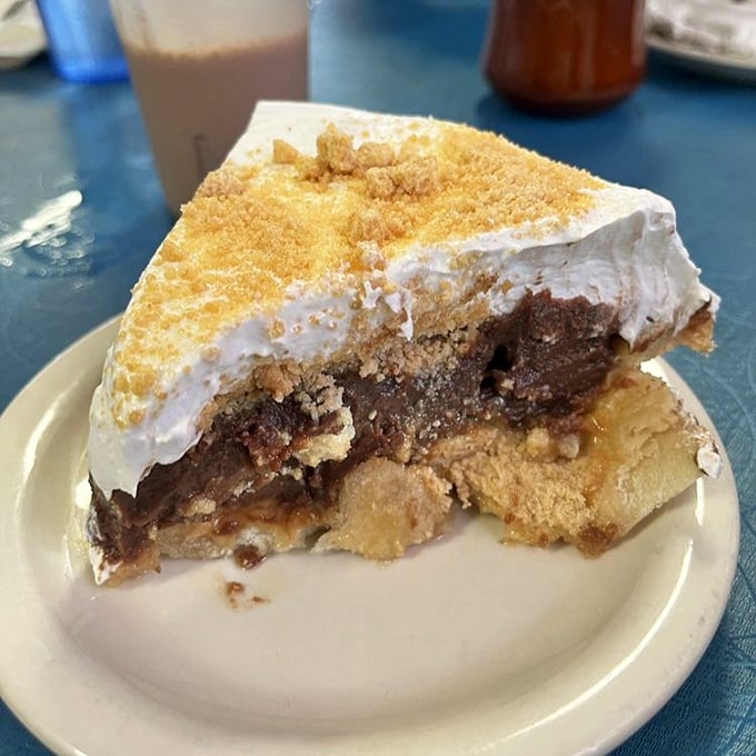 The legendary chocolate peanut butter pie in all its glory &ndash; layers of creamy peanut butter filling topped with whipped cream and crumbles. Diet plans have been abandoned for less.
