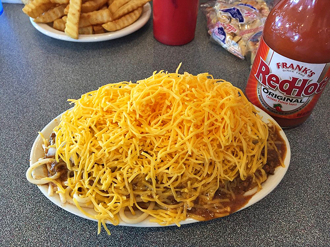 Behold the legendary Cincinnati three-way: spaghetti, chili, and a mountain of finely shredded cheddar that could double as an Olympic ski slope.