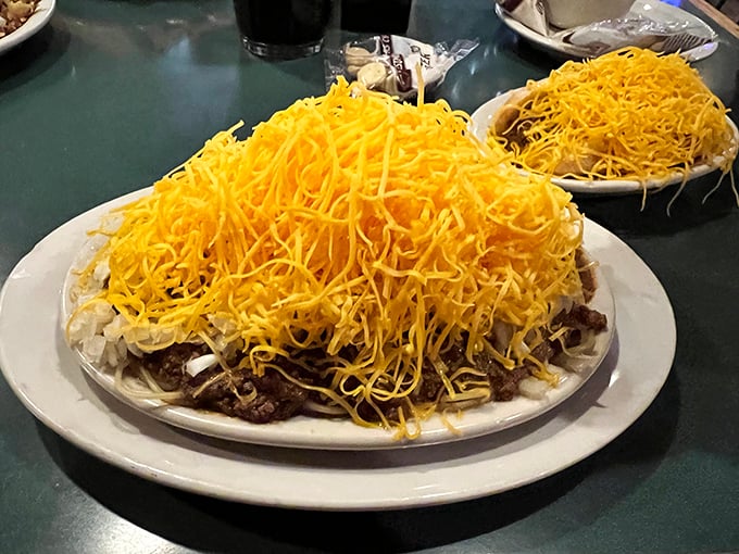 Behold the famous Cincinnati chili in its natural habitat—buried under a golden avalanche of cheese. This isn't just food; it's an engineering marvel.