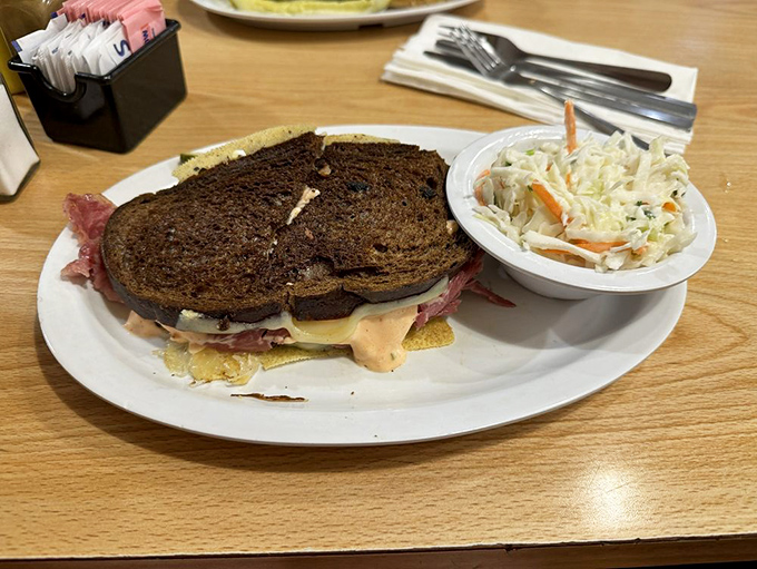 The classic Reuben arrives like a work of art &ndash; corned beef, sauerkraut, and Swiss on rye with a side of creamy coleslaw for good measure.