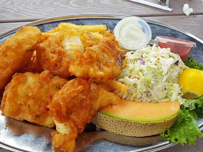 Golden-battered cod that shatters like glass, revealing pearly white flesh within. This isn't just fish and chips &ndash; it's edible poetry served with coleslaw and a slice of melon.